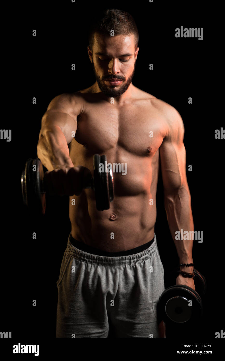 Muscular Model Doing Heavy Weight Exercise For Shoulder With Dumbbells ...