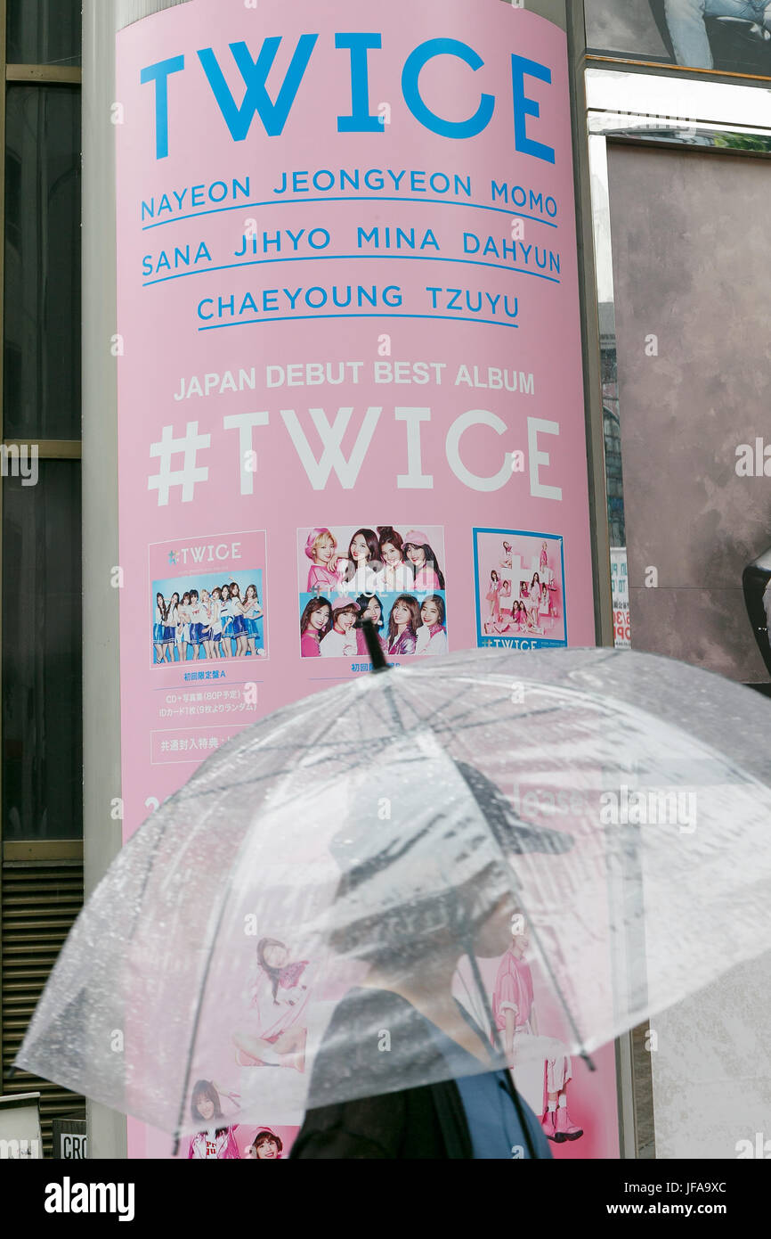 A woman walks past an advertisement for the new album #Twice on display ...
