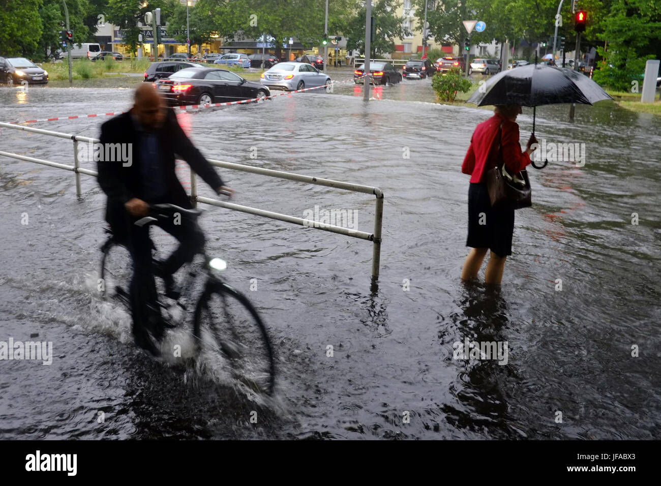 Berlin, Germany. 29th June, 2017. A woman cycles along a flooded street ...