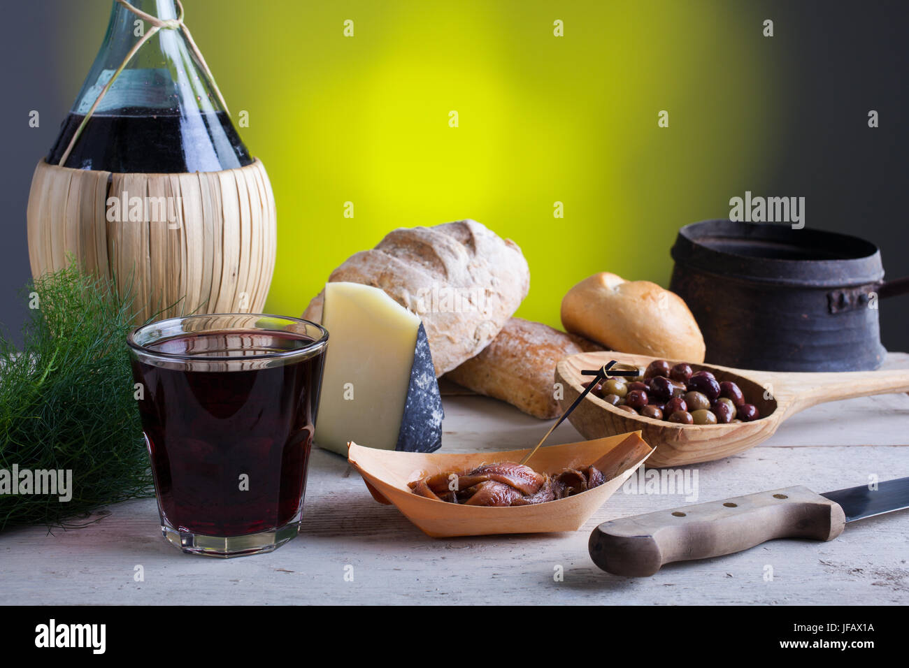 Italian slow food on the white table. Olives, cheese, bread, anchovies ...