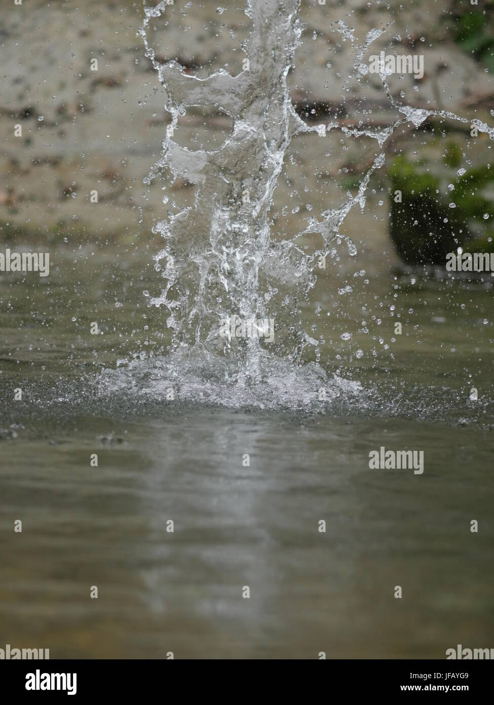 Close up view of water splash with many drops in some natural basin ...