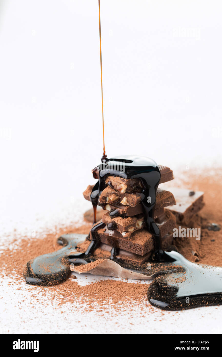 Chocolate slices with cocoa powder, syrup on clean white background ...