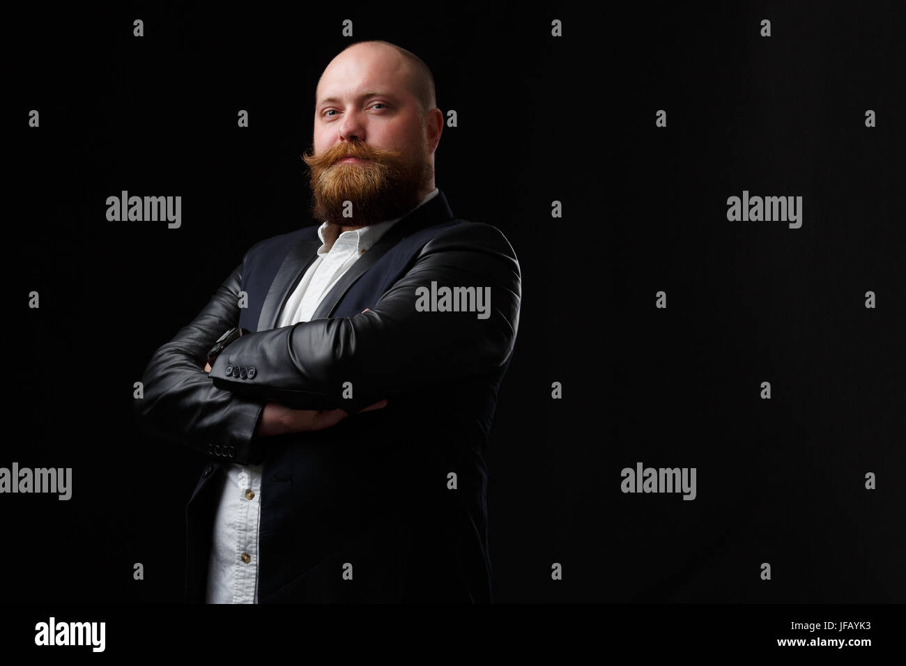 Stout man with ginger beard and mustache with his arms crossed over ...
