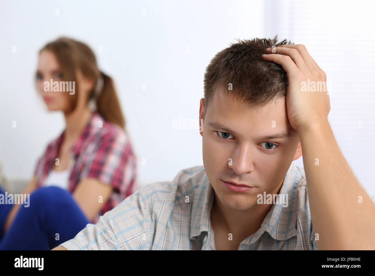 Portrait of unhappy young couple having problems. Focus on man Stock ...