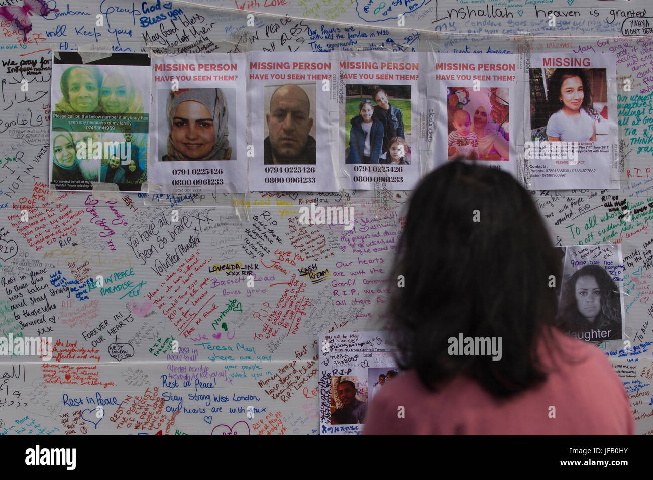 People leave tributes on a wall off condolence to the victims who died ...