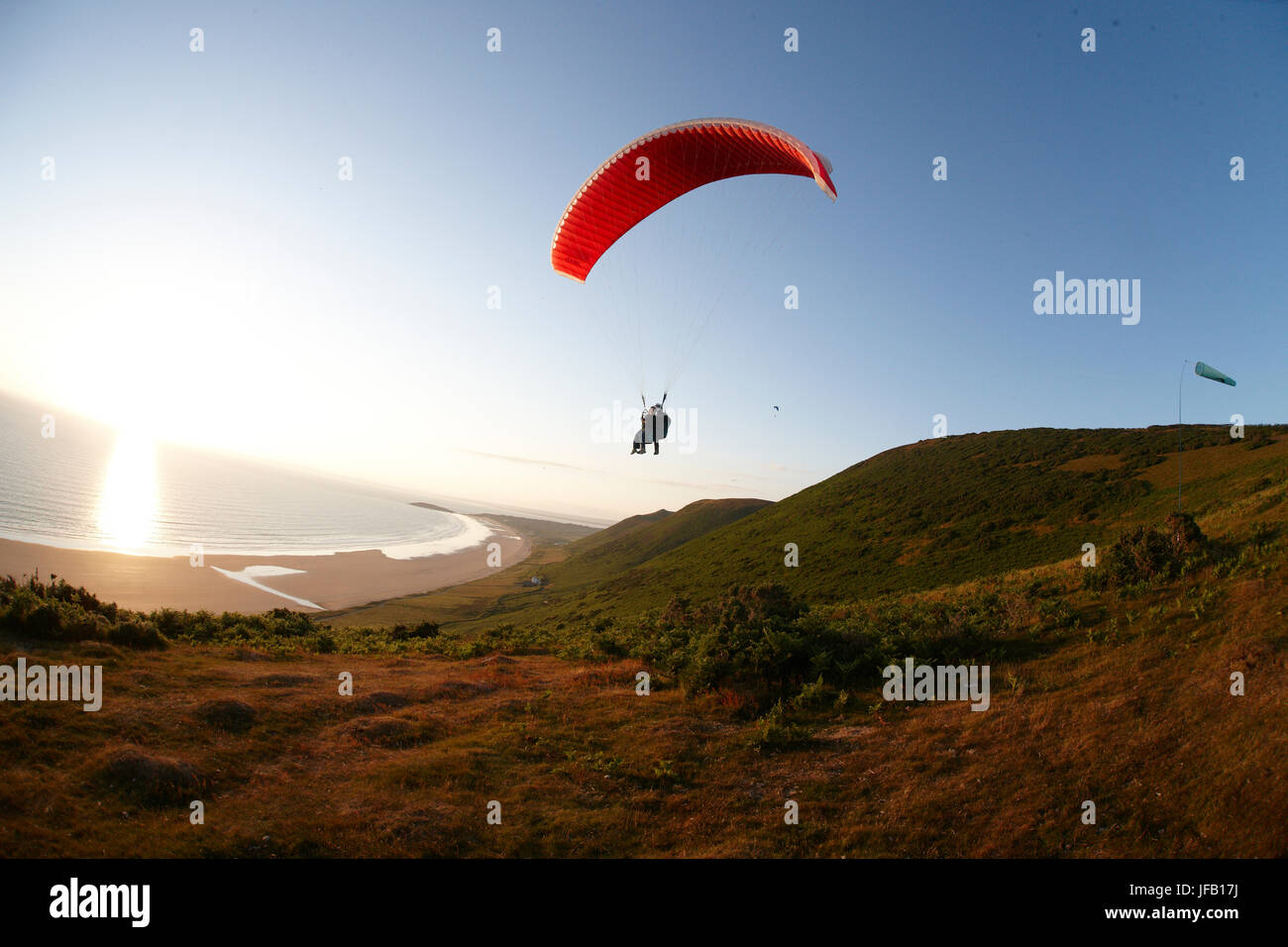 Tandem paragliding over the ocean Stock Photo - Alamy