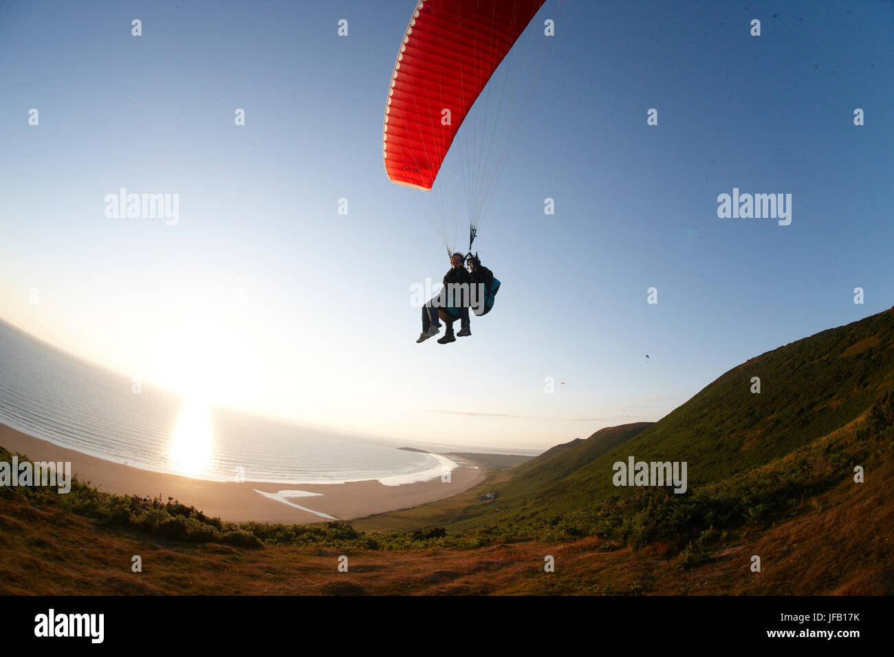 Tandem paragliding over the ocean Stock Photo - Alamy