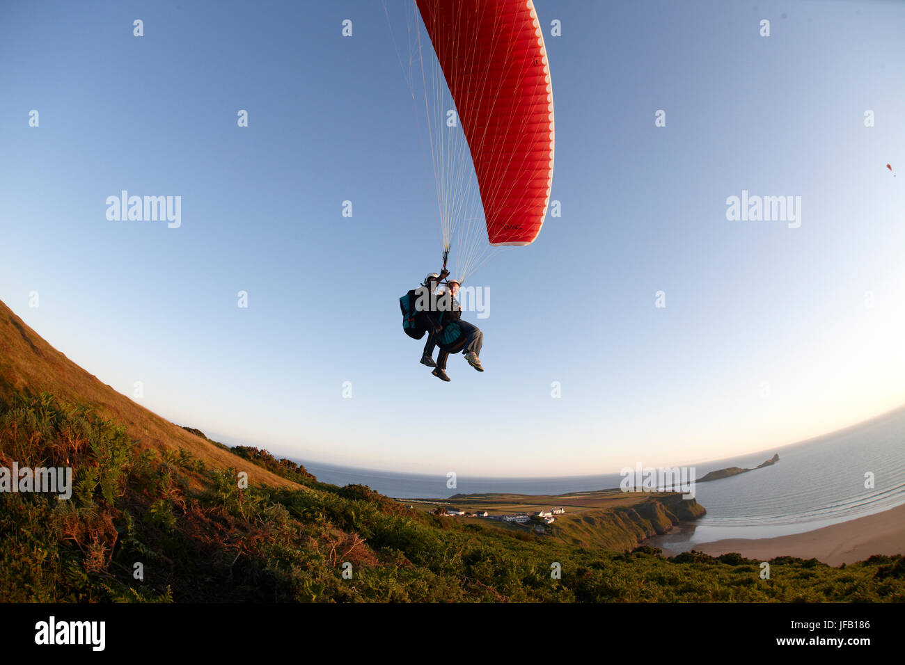 Tandem paragliding over the ocean Stock Photo - Alamy