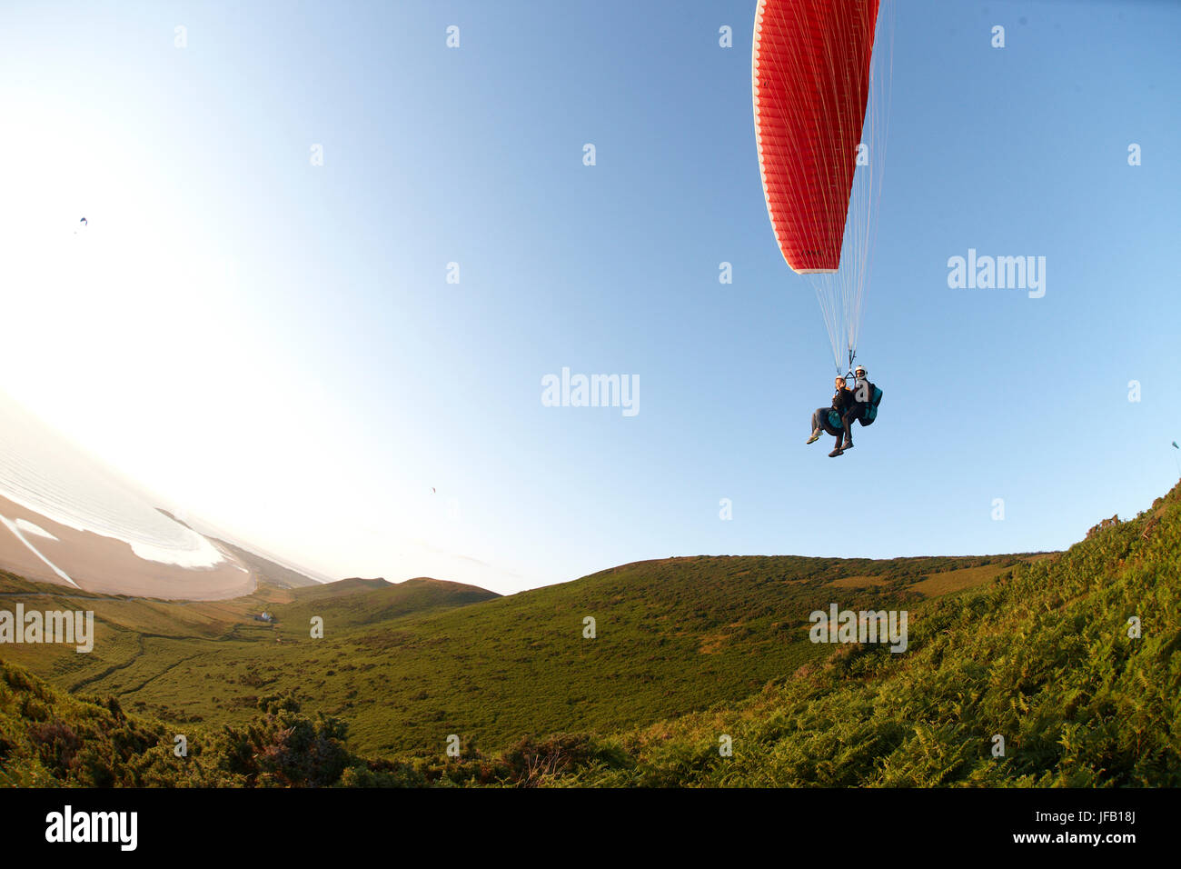Tandem paragliding over the ocean Stock Photo - Alamy
