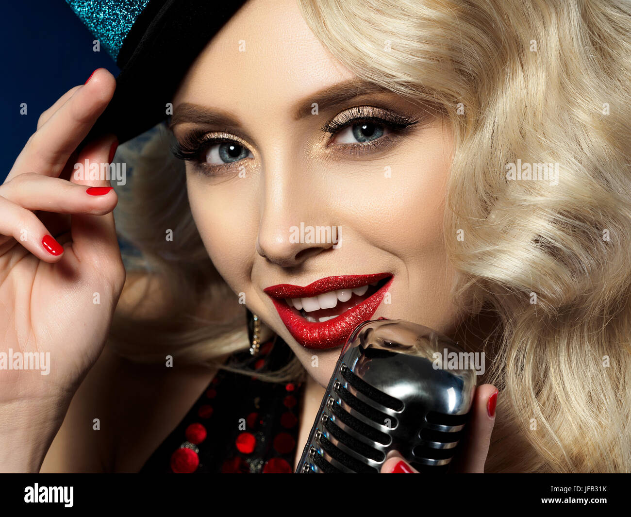Close up portrait of pretty blond female singer holding retro styled ...