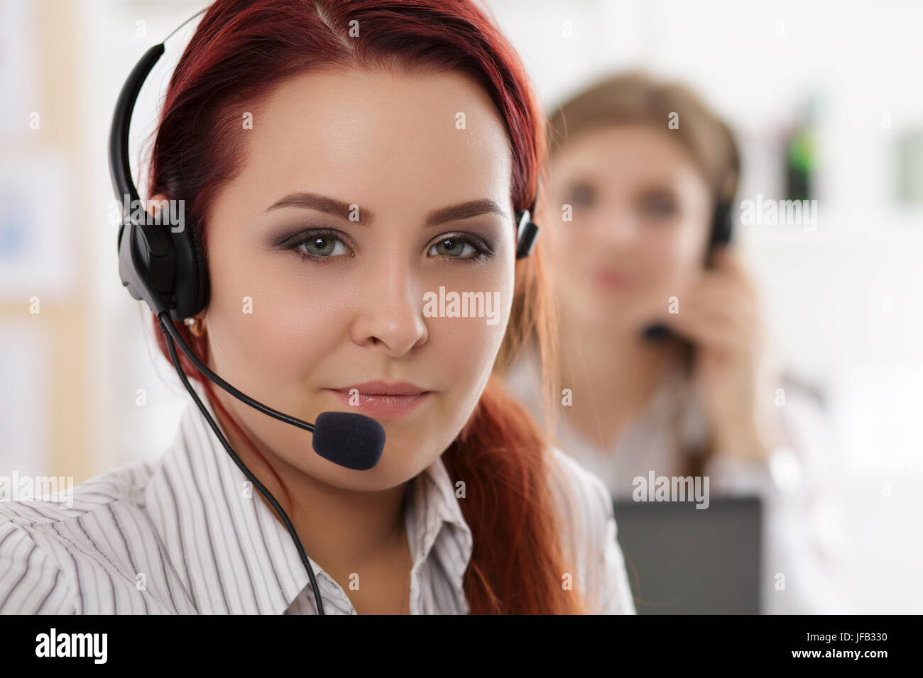 Portrait of call center worker accompanied by her team. Smiling ...