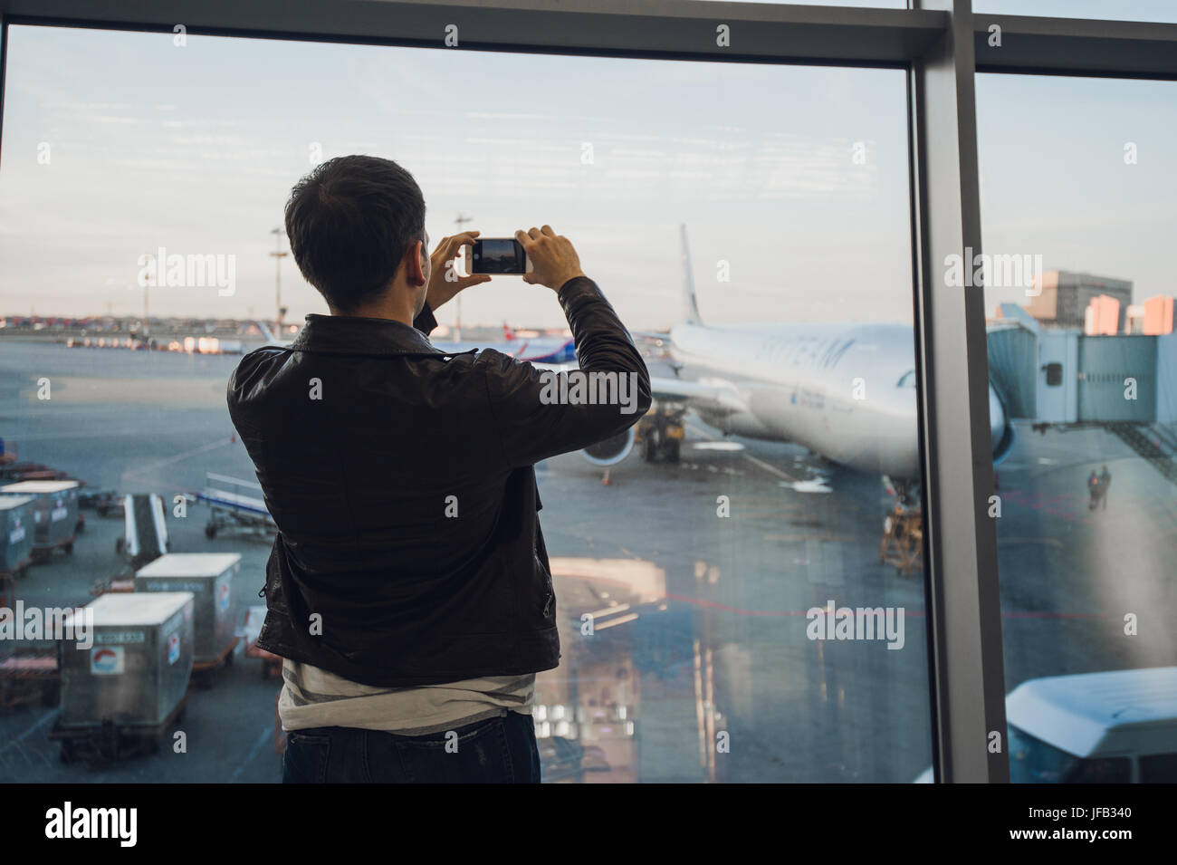 Man hand take picture of airplane using cellphone. Tourism concept ...
