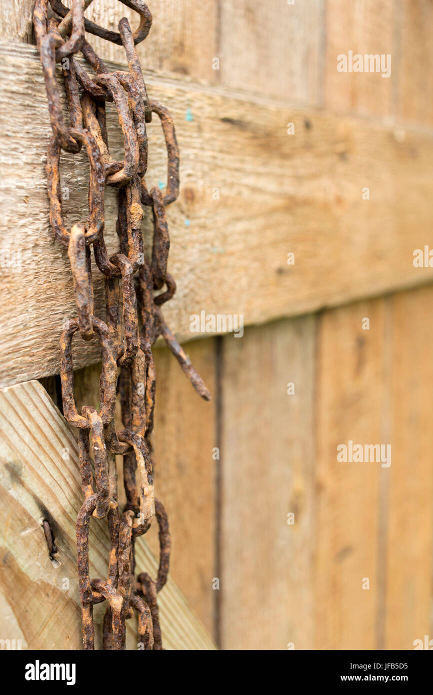 Rusty old metal chain on a wooden background. Rusty links of the chain ...