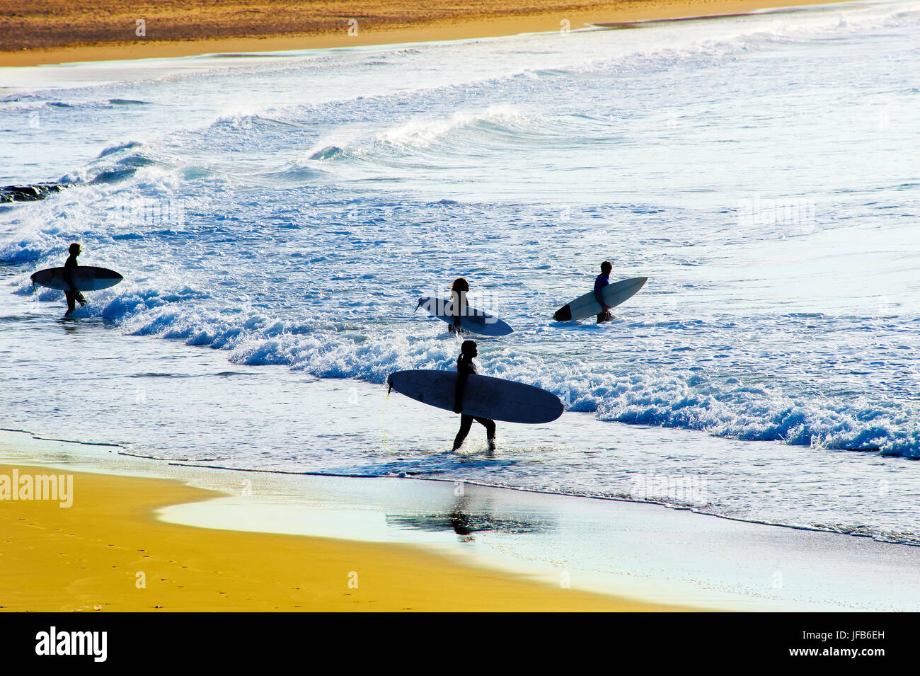Surfing at sunset Stock Photo - Alamy