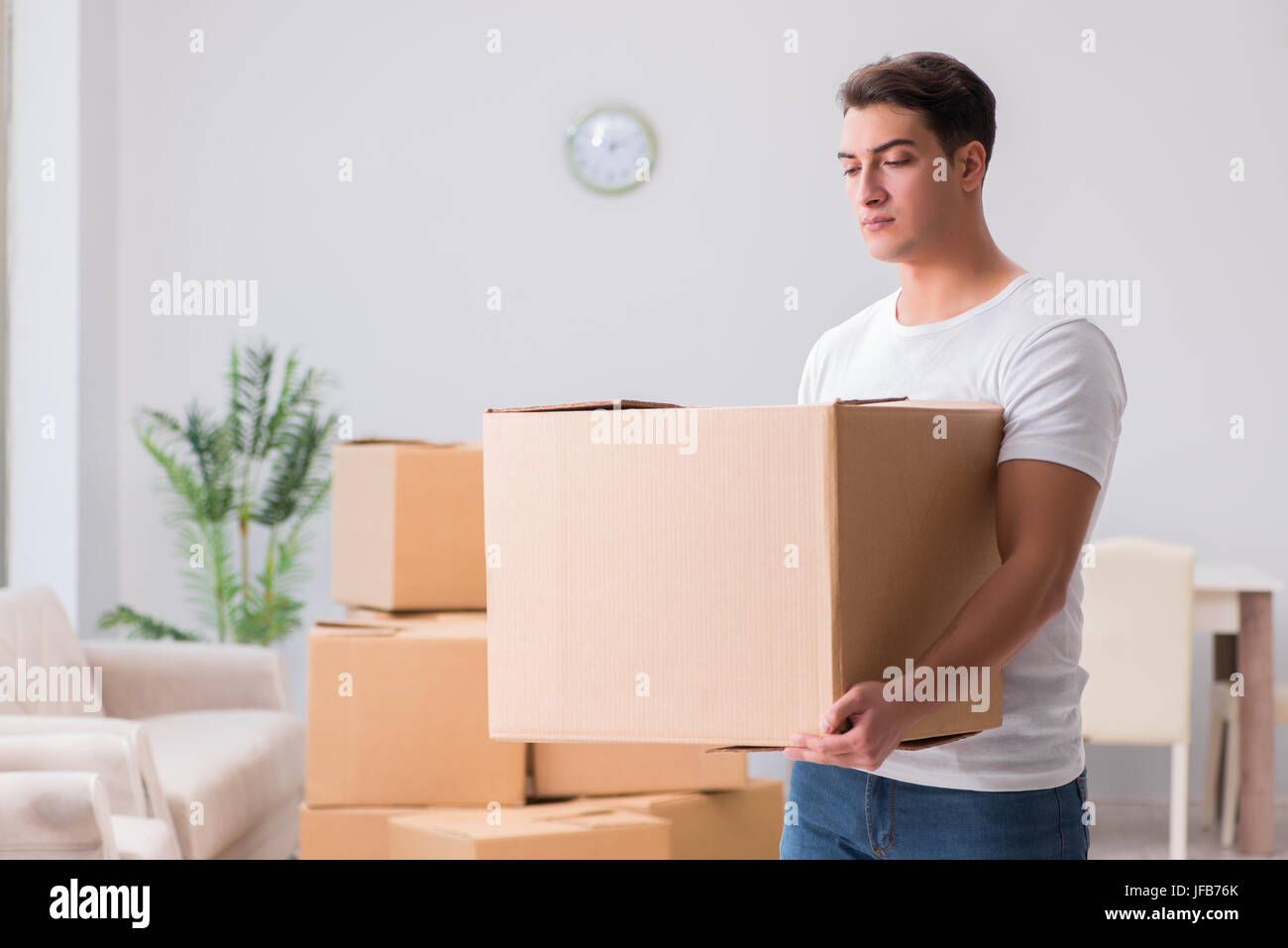 Man delivering heavy boxes at home Stock Photo - Alamy