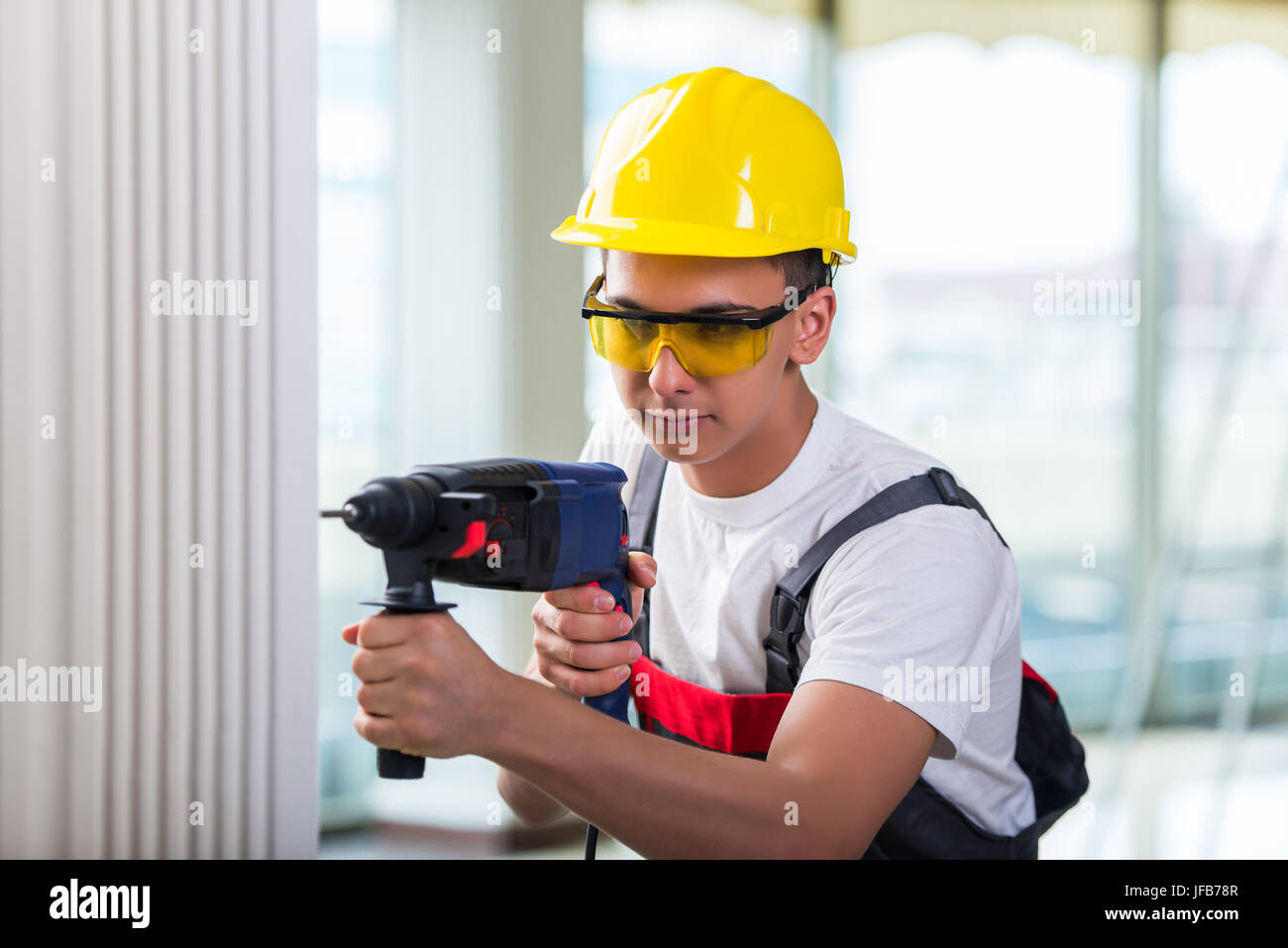 Man drilling the wall with drill perforator Stock Photo - Alamy