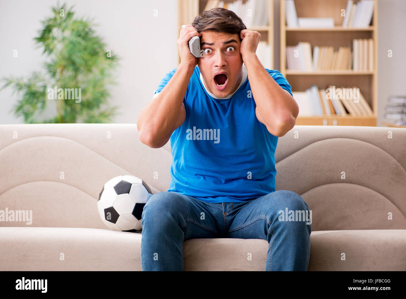 Man watching football at home Stock Photo - Alamy