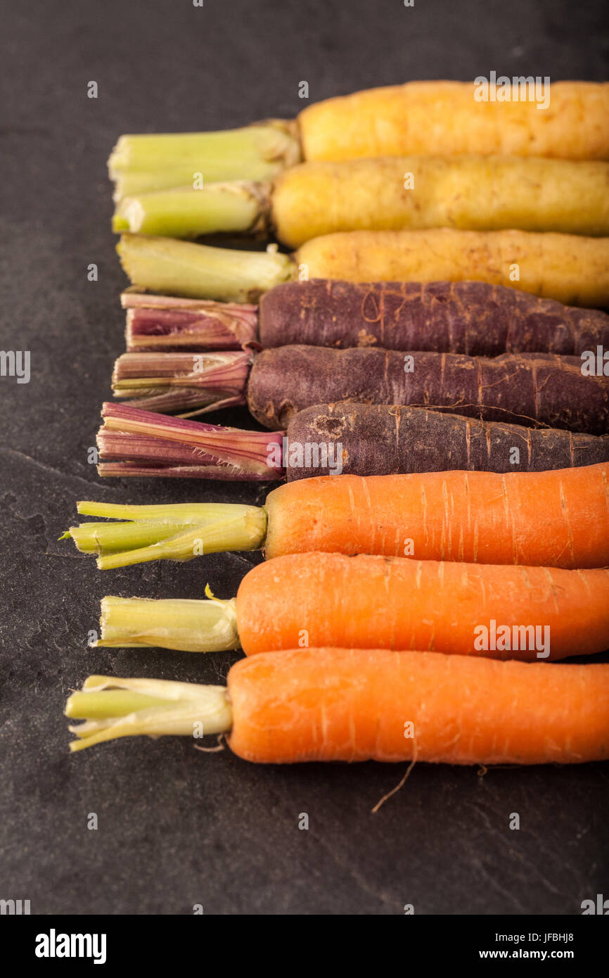 Baby Rainbow Carrots on Grey Slate Background Stock Photo - Alamy