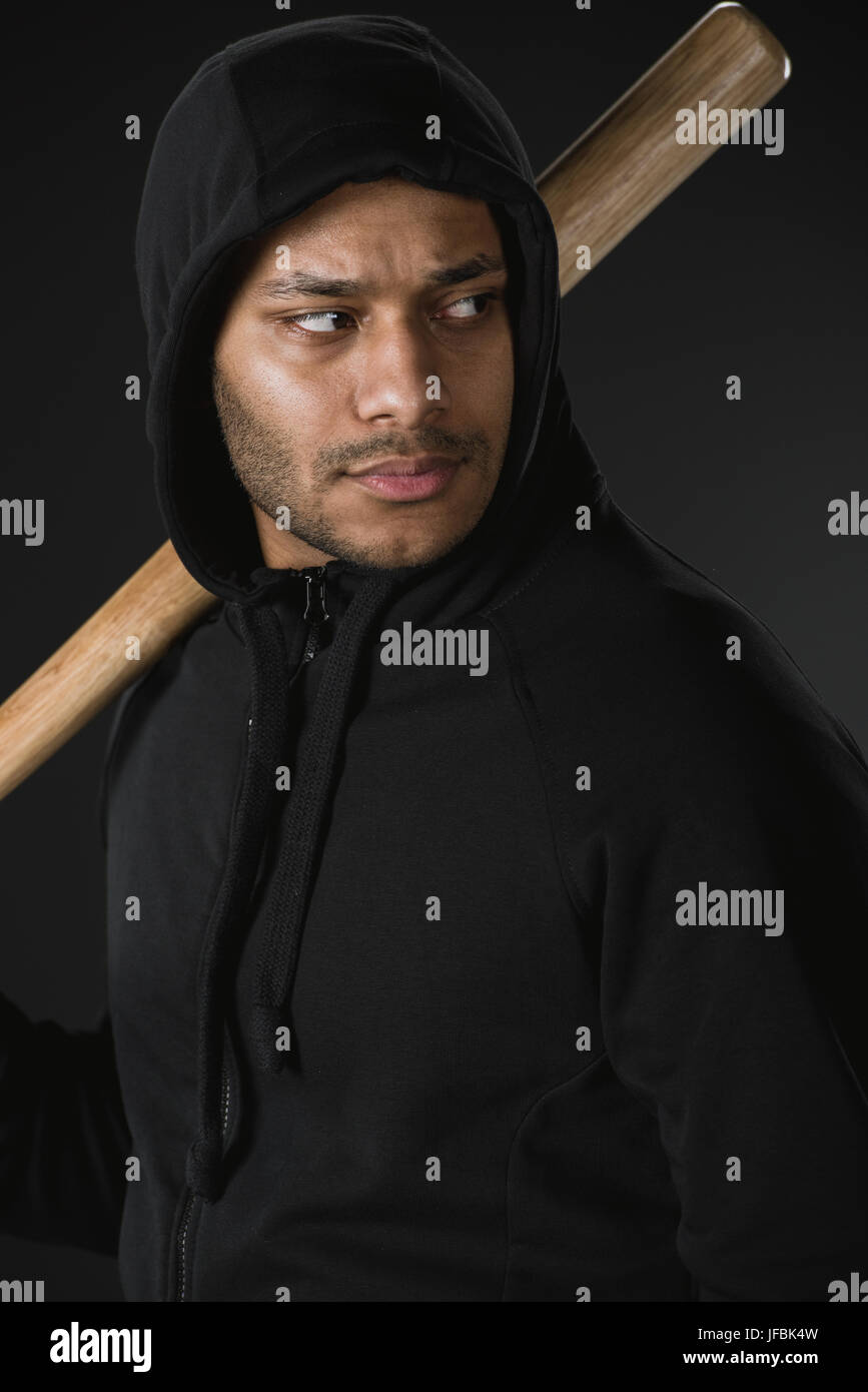 young african american robber in zoodie with baseball bat isolated on ...