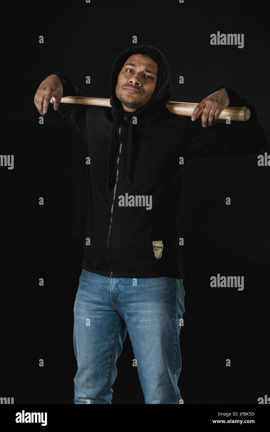young african american robber in zoodie with baseball bat isolated on ...