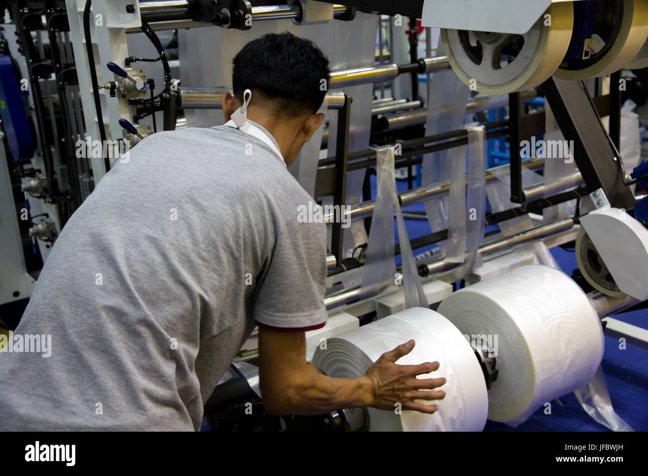 Worker operating plastic bag blowing machine Stock Photo - Alamy