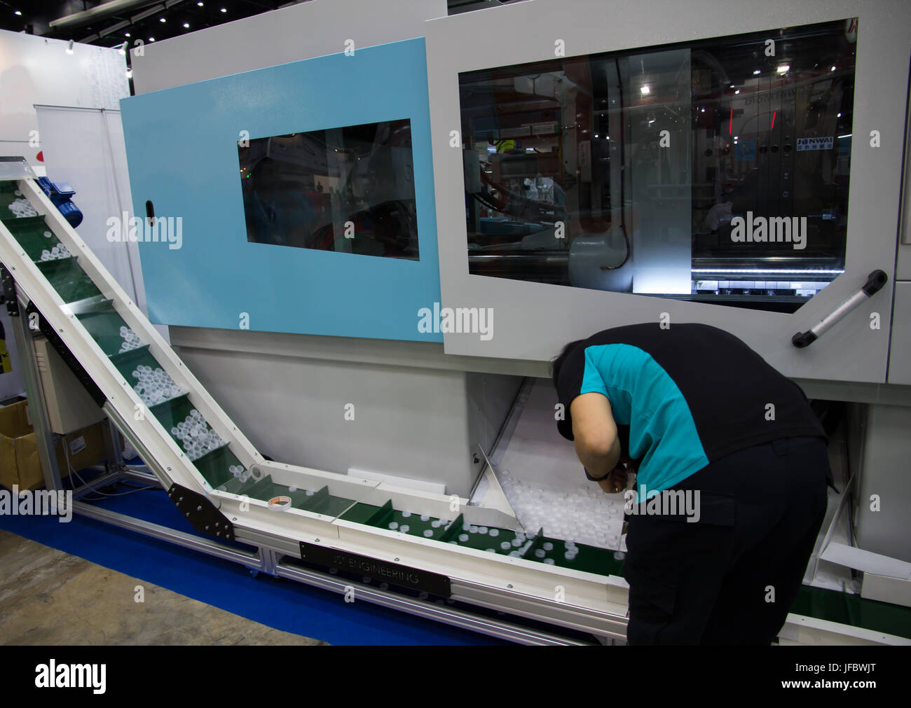 Worker operating bottle cap making machine Stock Photo - Alamy