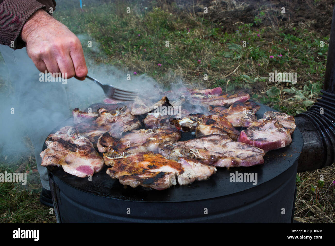 Grilling meat on wood stove Stock Photo - Alamy