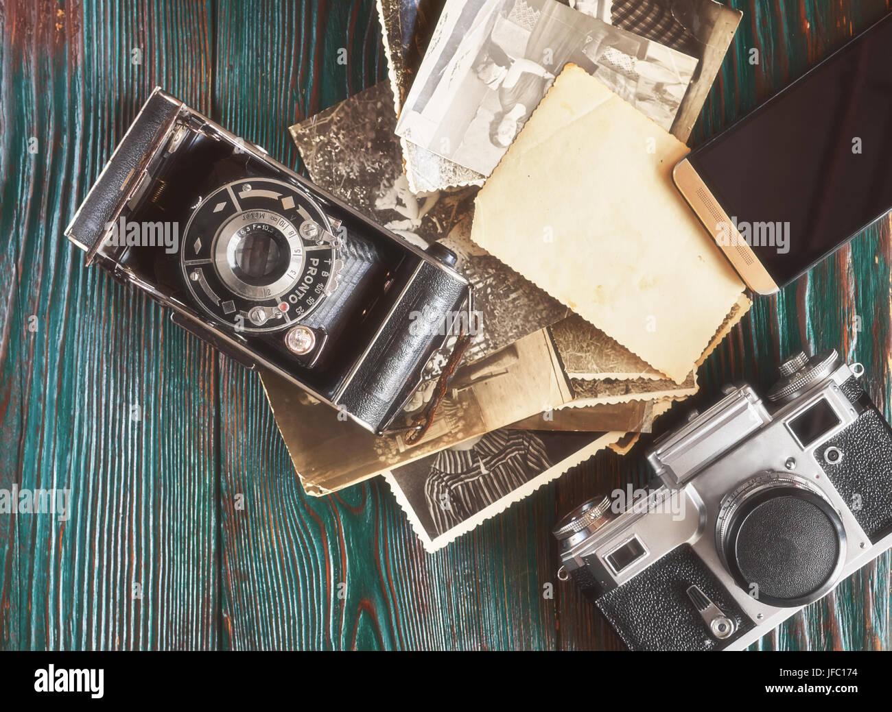 Three generations of a photo cameras and old photos on memory. Ancient ...