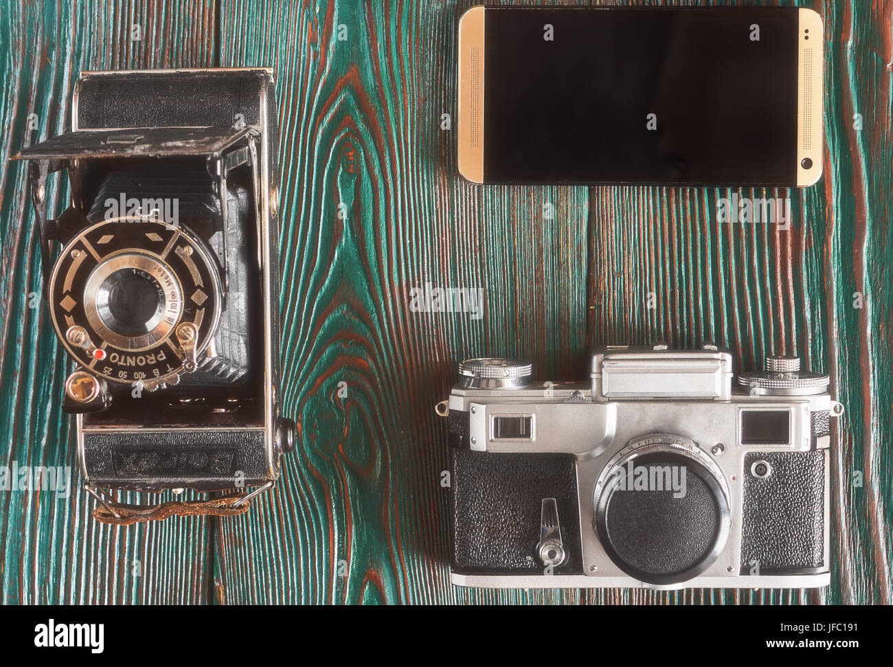 Three generations of a photo cameras and old photos on memory. Ancient ...