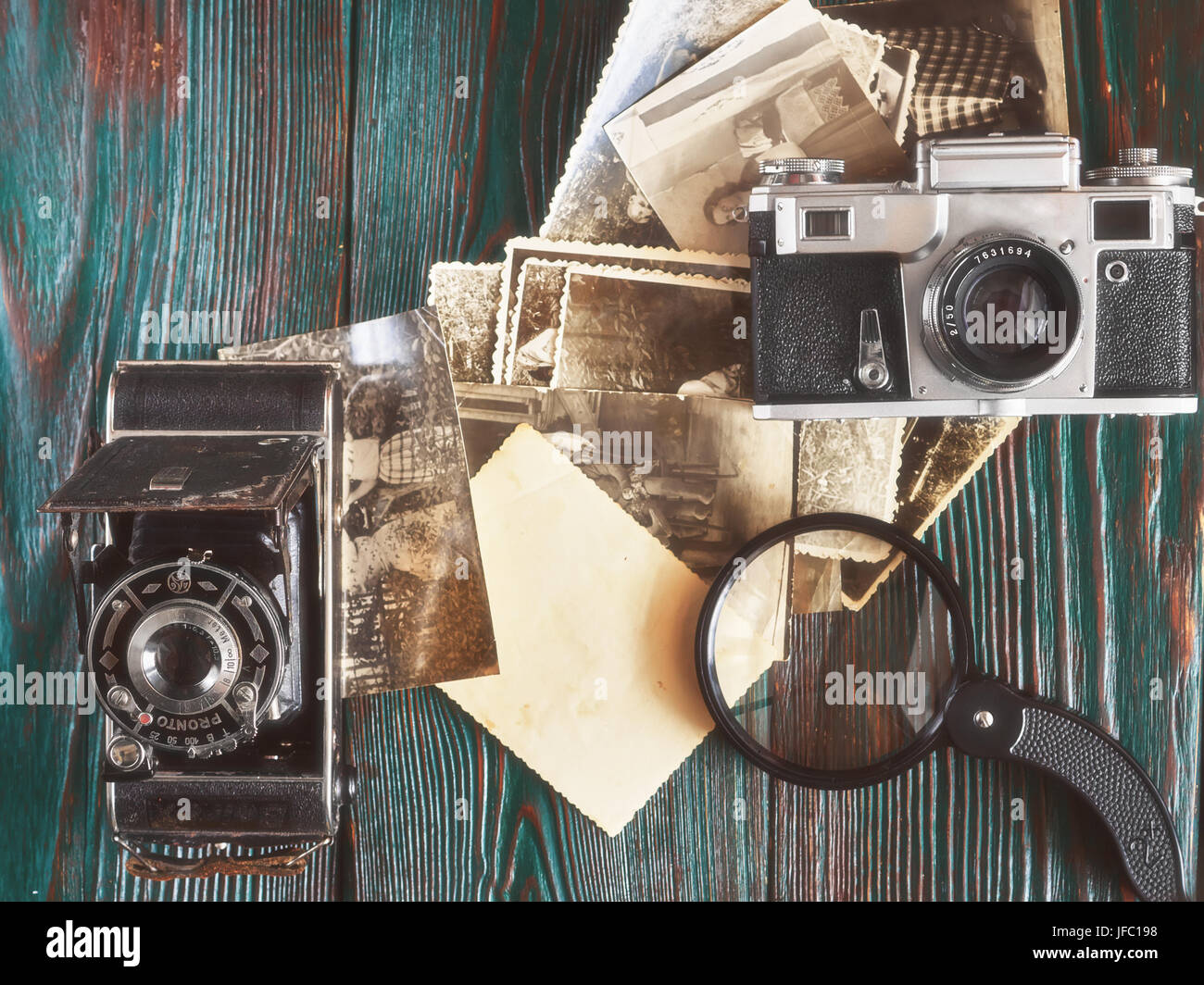 Three generations of a photo cameras and old photos on memory. Ancient ...