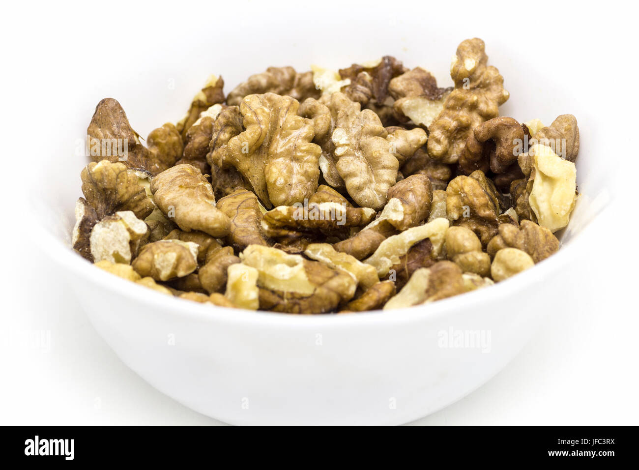 Peeled walnuts in a cup closeup on a white background Stock Photo - Alamy