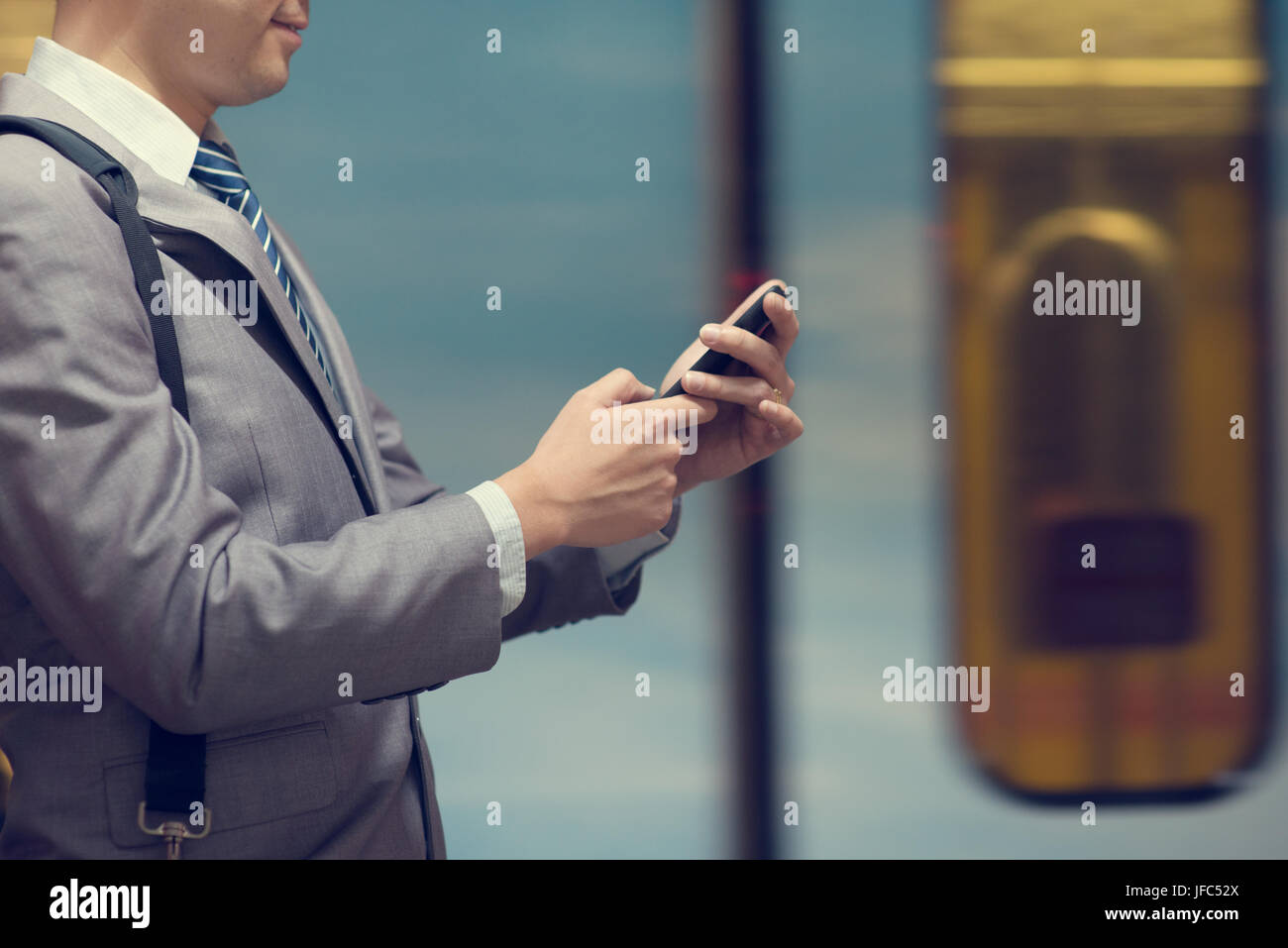 Business people hand using smart phone in subway station, train passing ...