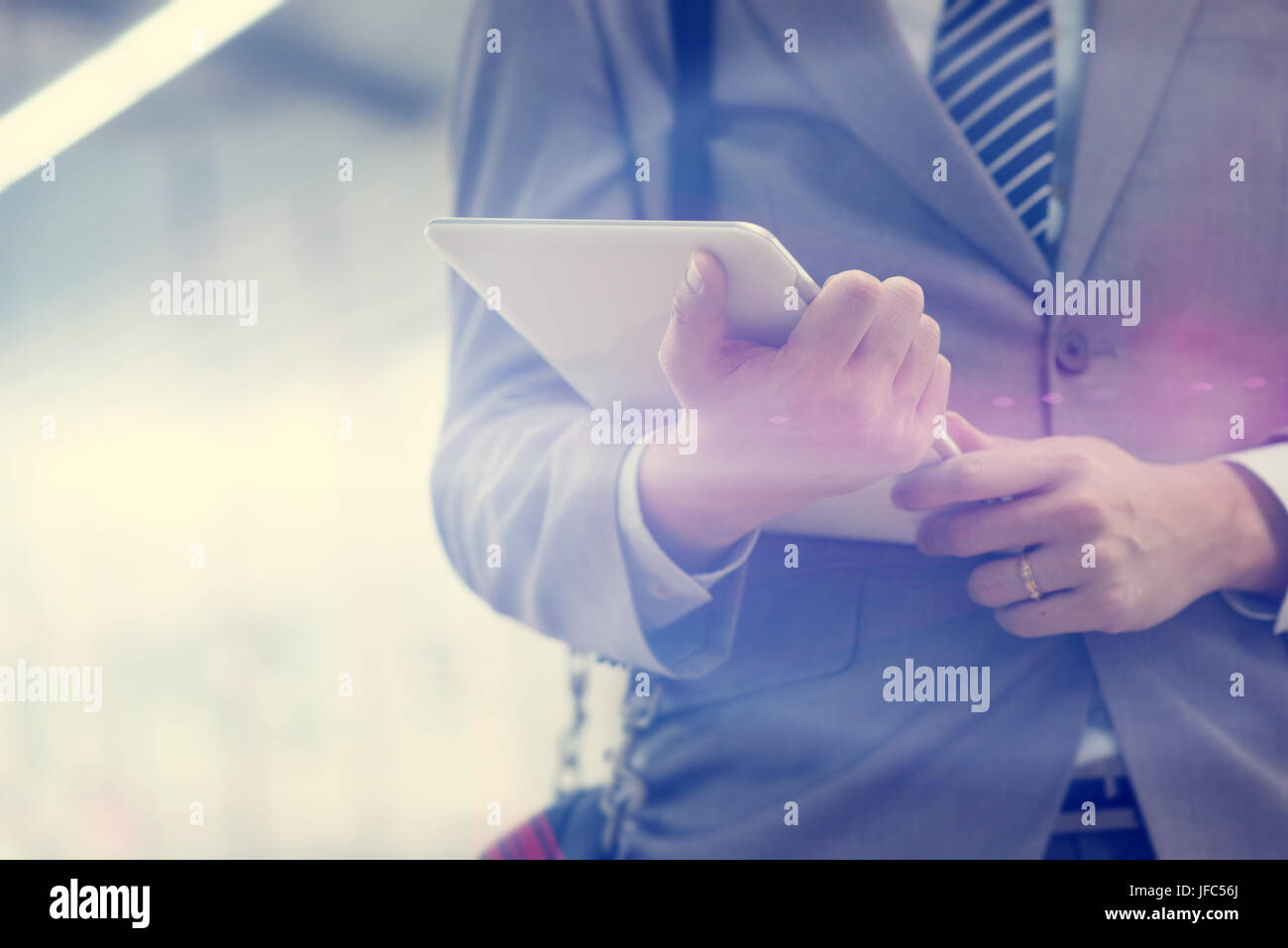 Businessman hand holding digital tablet pc at train station, with ...
