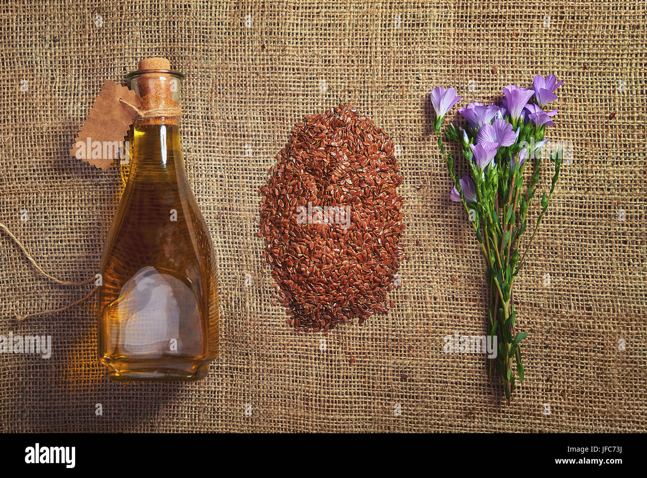 Flax flower, seeds and butter in a glass old bottle with a vintage ...