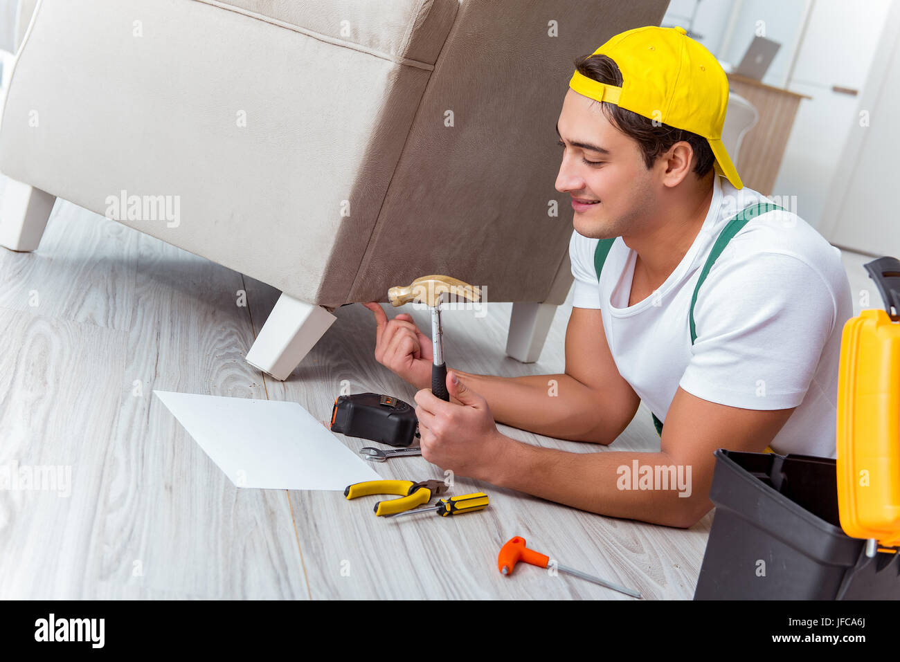 Worker repairing furniture at home Stock Photo - Alamy