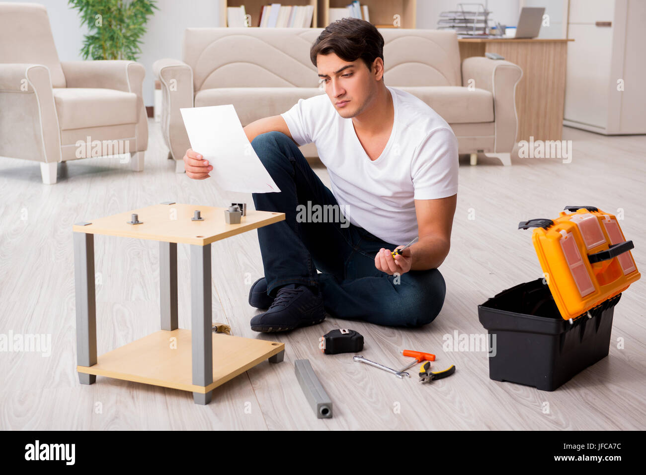 Man assembling shelf at home Stock Photo - Alamy