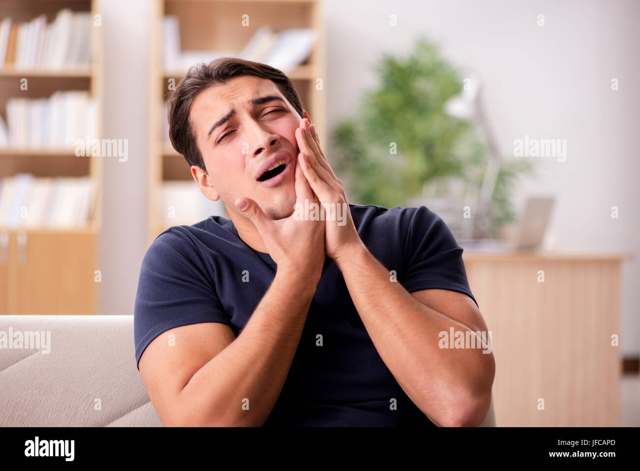 Young handsome man suffering from pain Stock Photo - Alamy