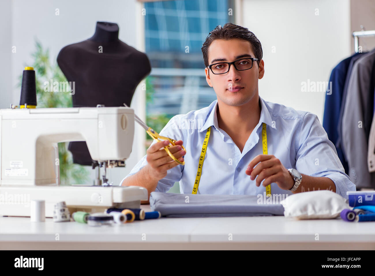 Young man tailor working on new clothing Stock Photo - Alamy