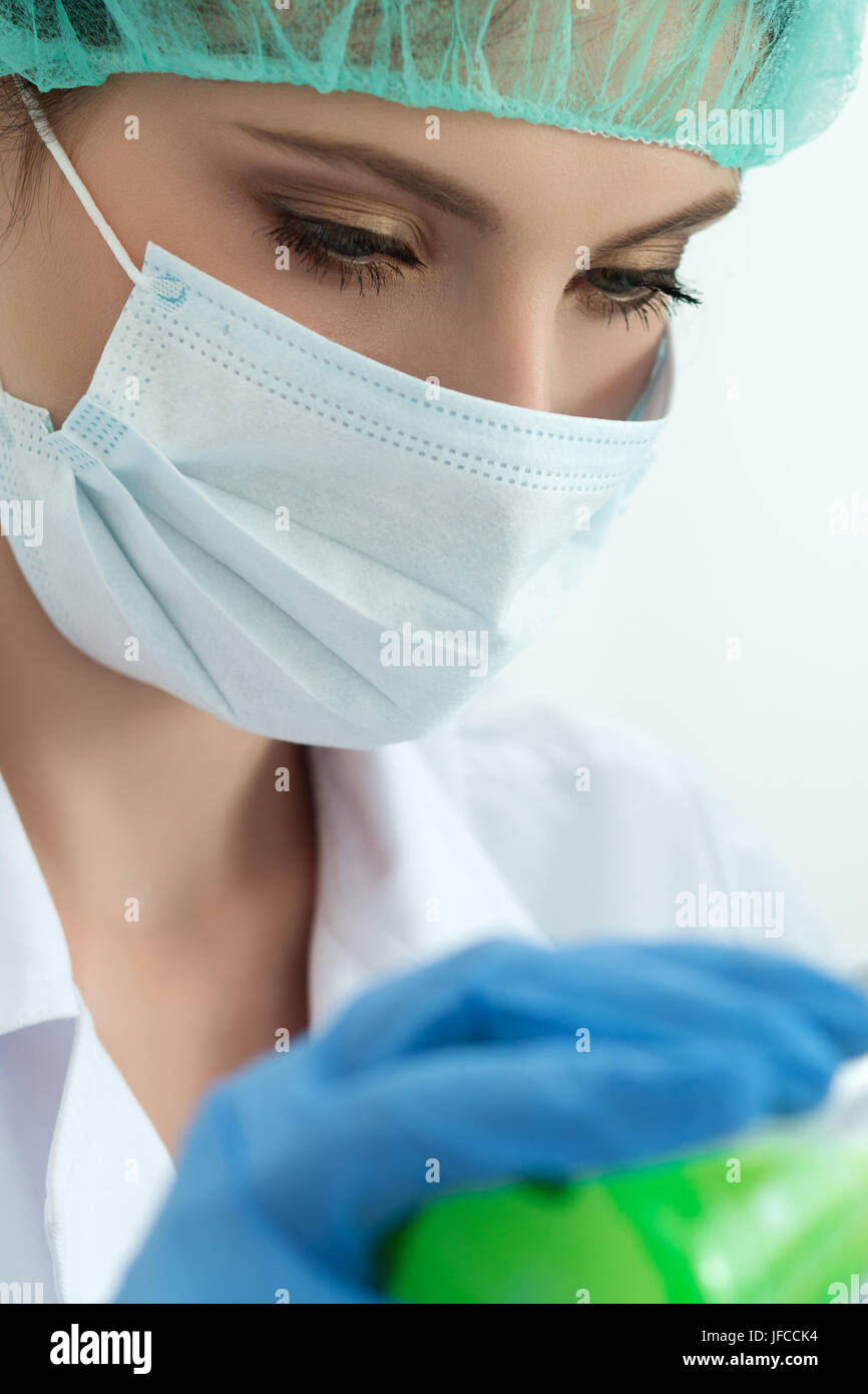 Medical doctor in protective gloves and surgical mask and hat working ...