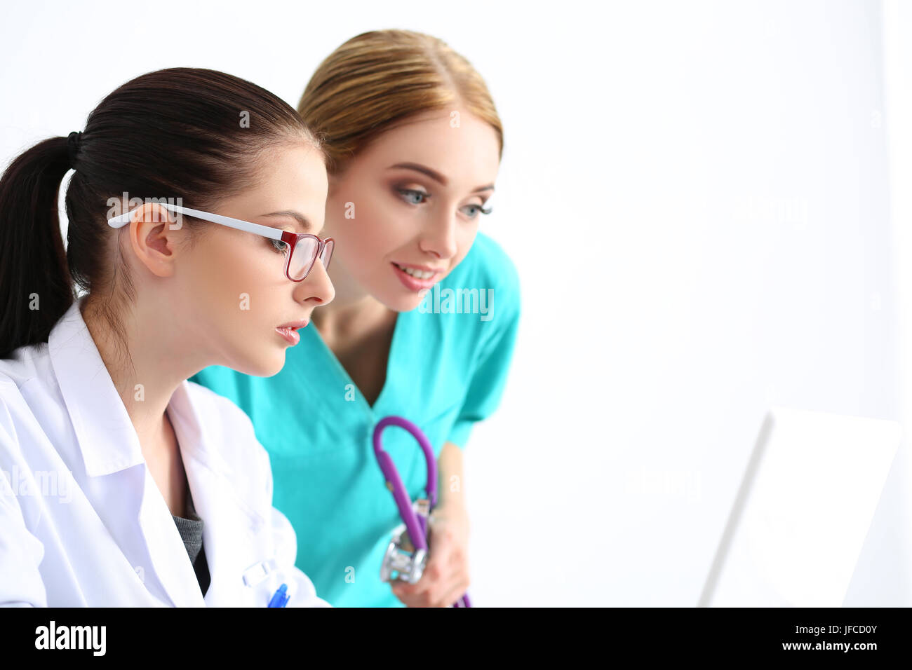 Two worried female medicine doctors looking at laptop monitor. Medical ...