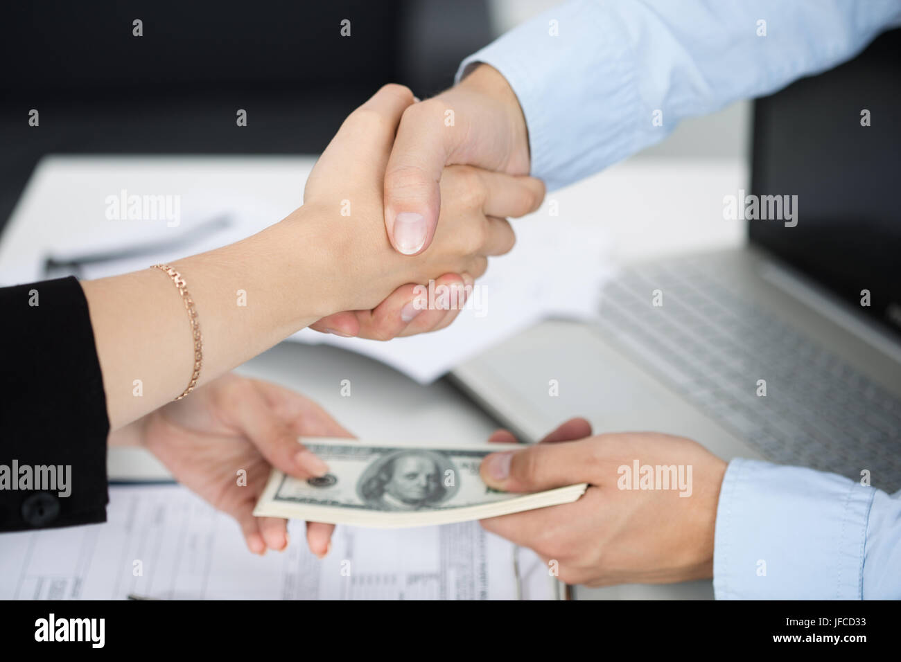 Woman and man handshake close up with the money in the other hands ...
