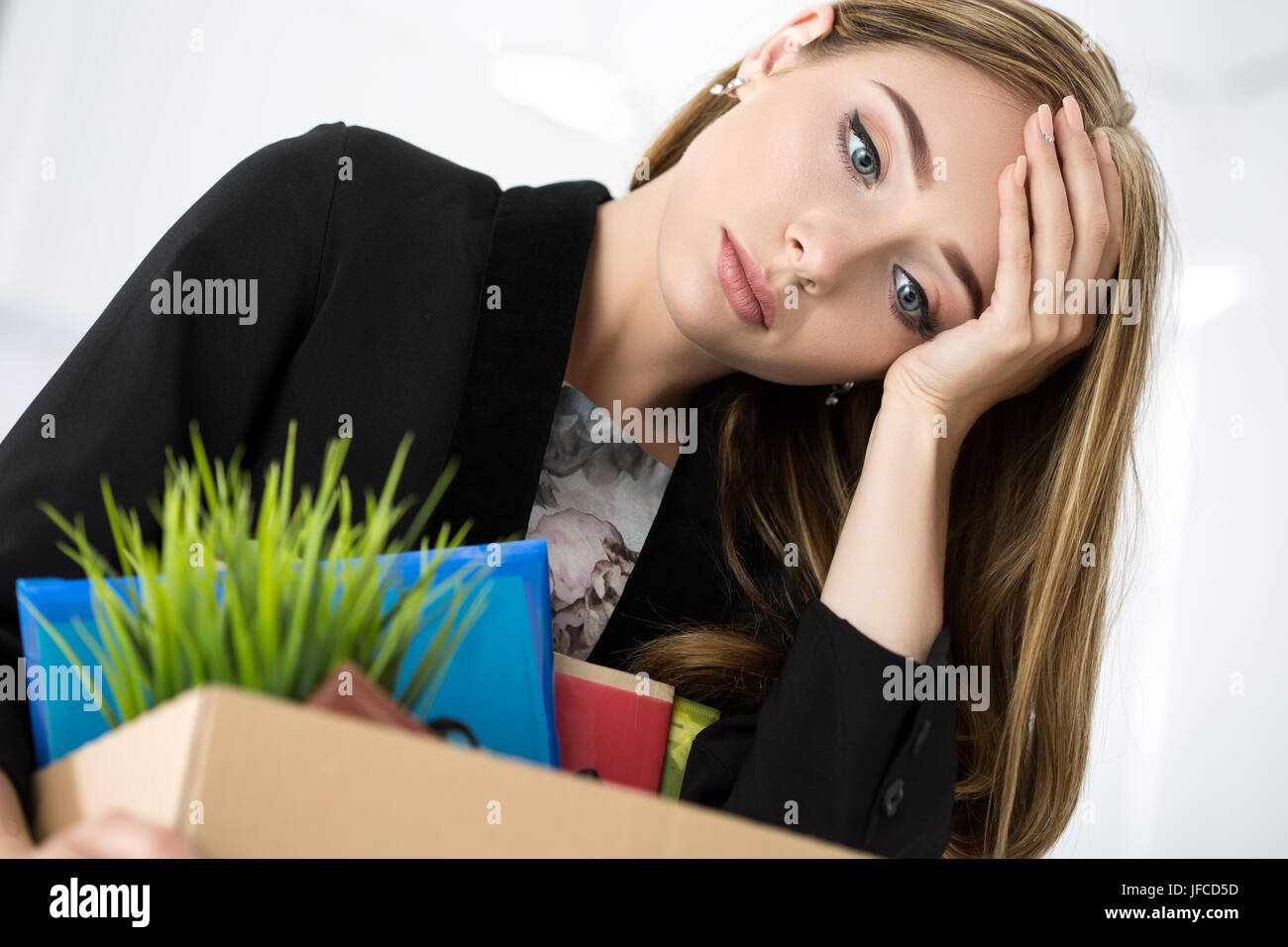 Young Dismissed Female Worker In Office Holding Carton Box With Her
