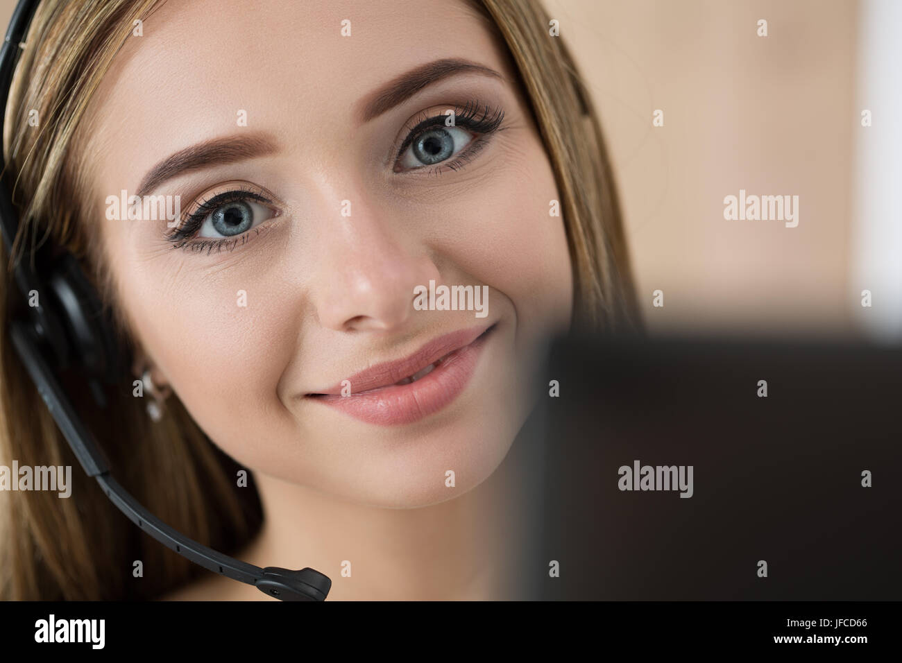 Portrait of beautiful call center operator at work. Woman with headset talking to someone online ...
