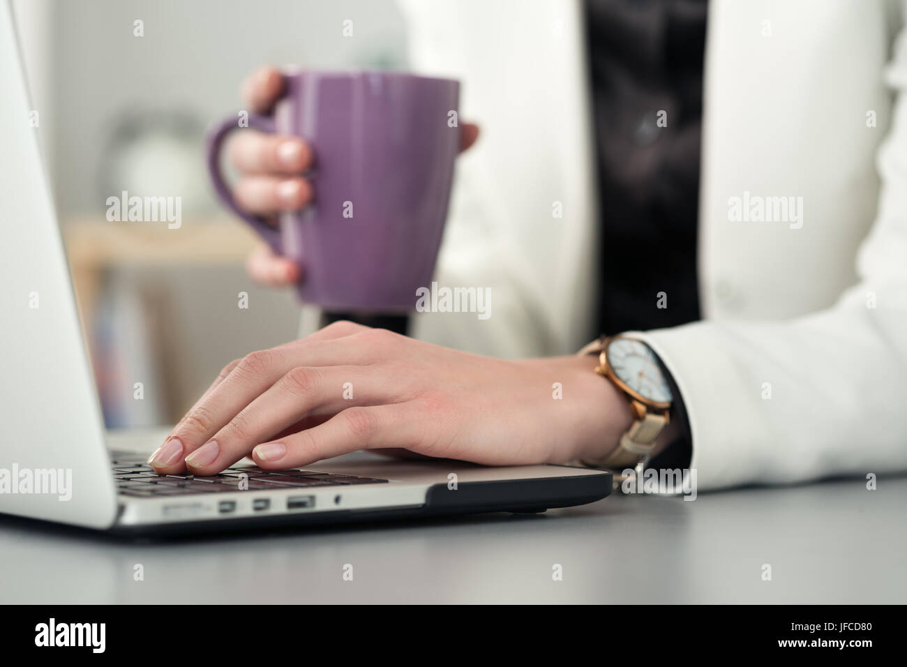 Close up view of female student at workplace holding cup of tea and ...