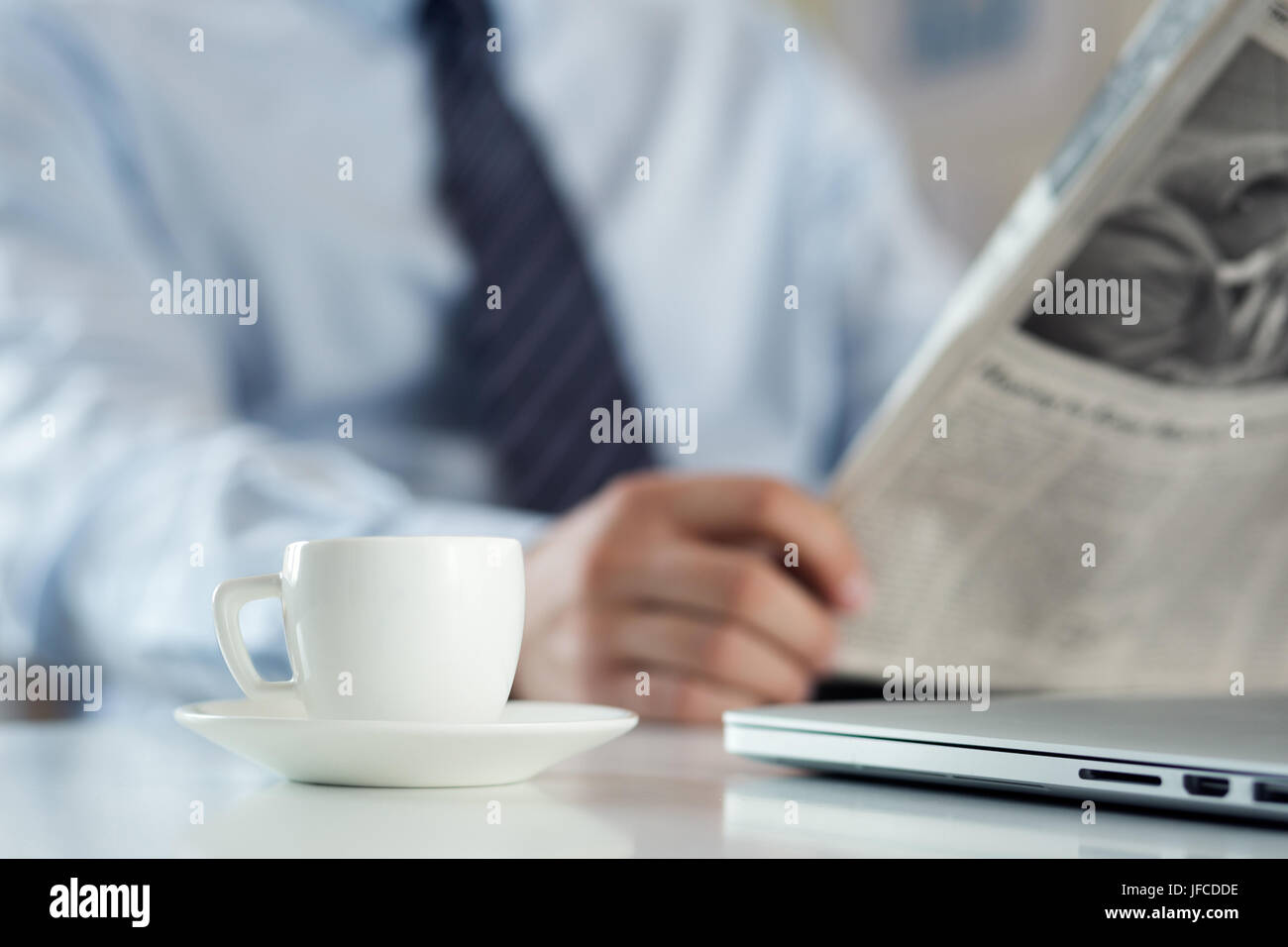 Cup of morning coffee on worktable with business analyst hold in hands ...