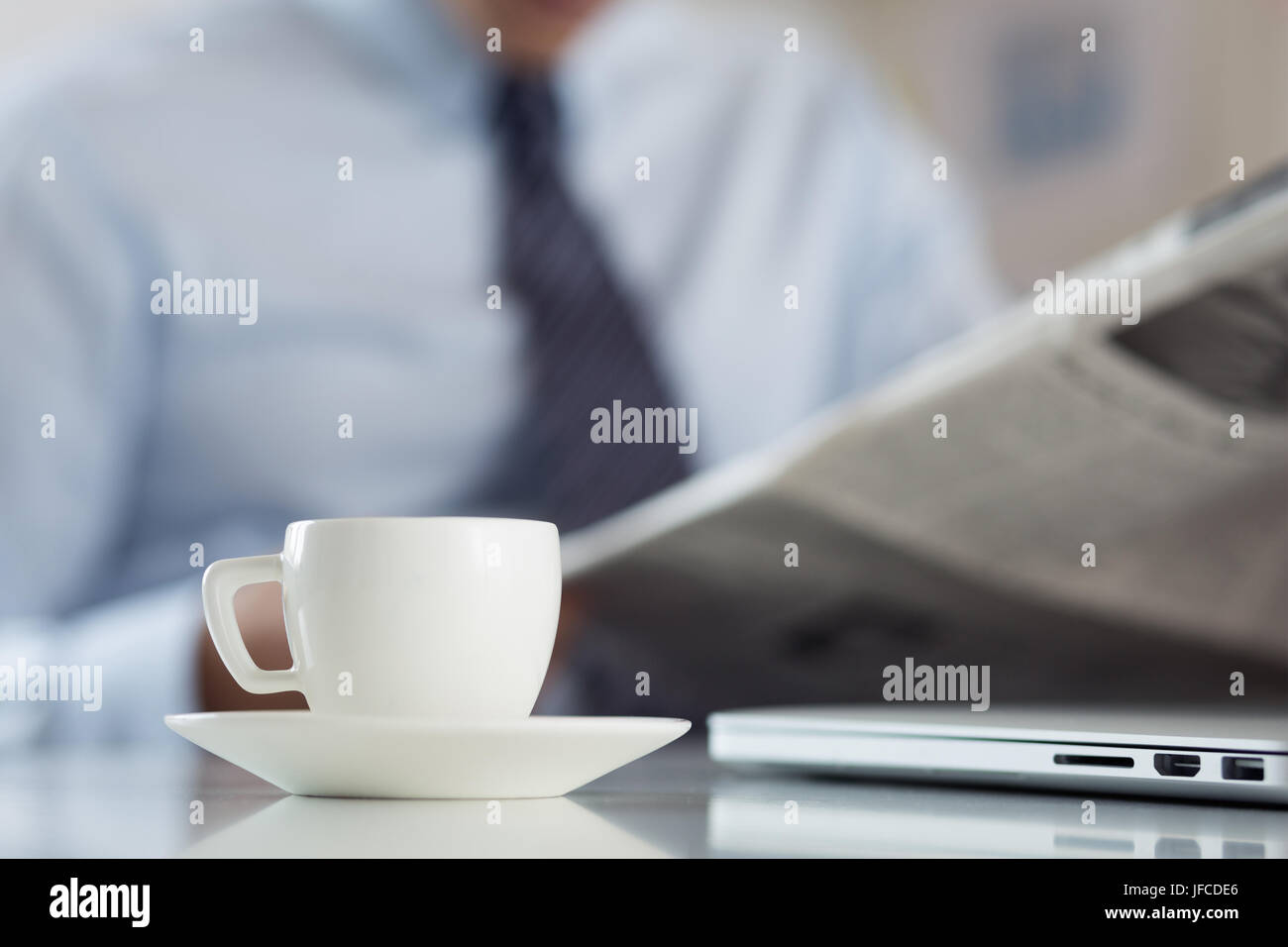 Cup of morning coffee on worktable with business analyst hold in hands ...