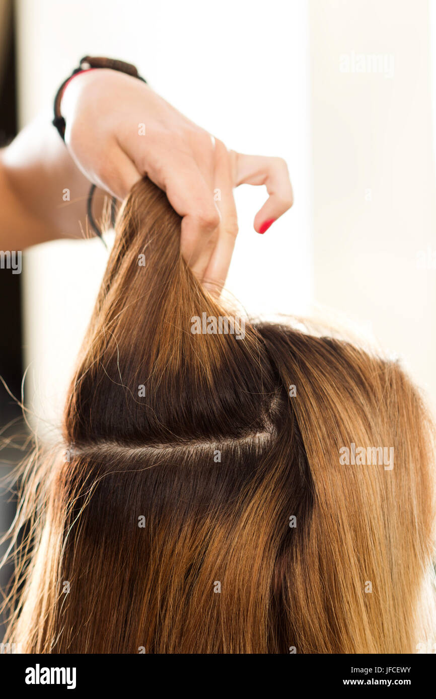 Close up view of hairdresser hand holding strand of hair preparing to ...