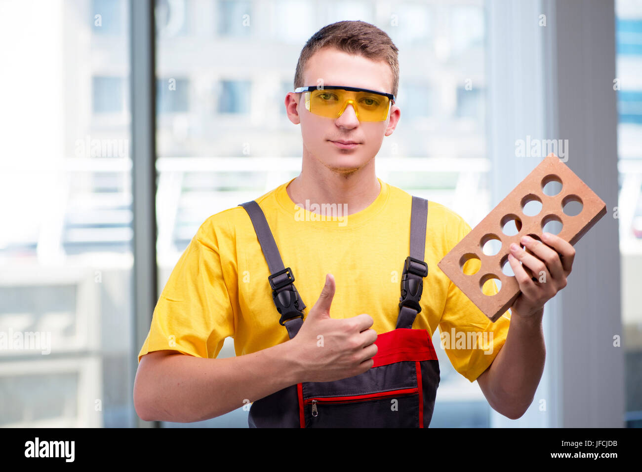 Young construction worker in yellow coveralls Stock Photo - Alamy