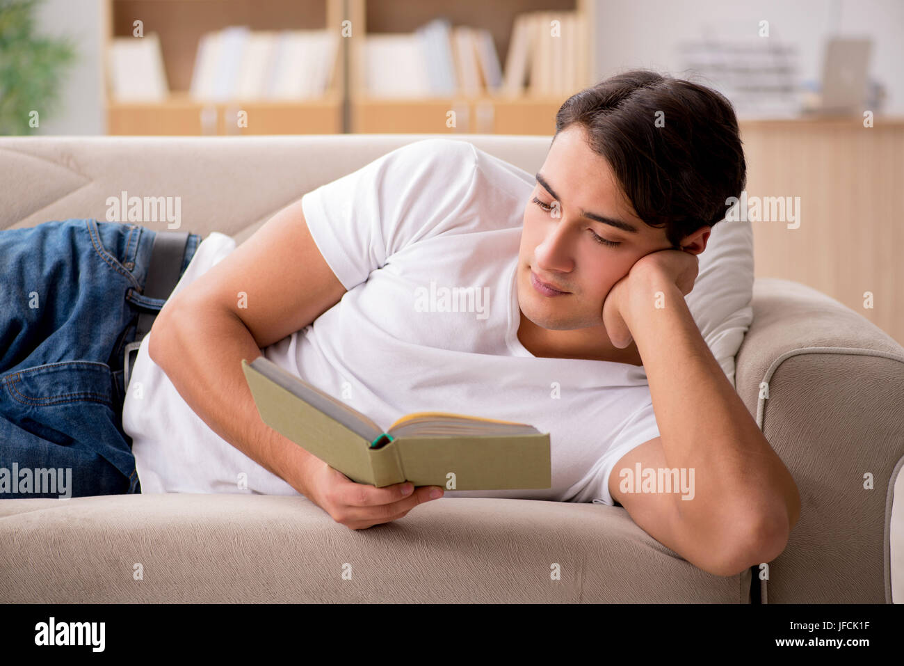 Handsome man lying on the sofa Stock Photo - Alamy