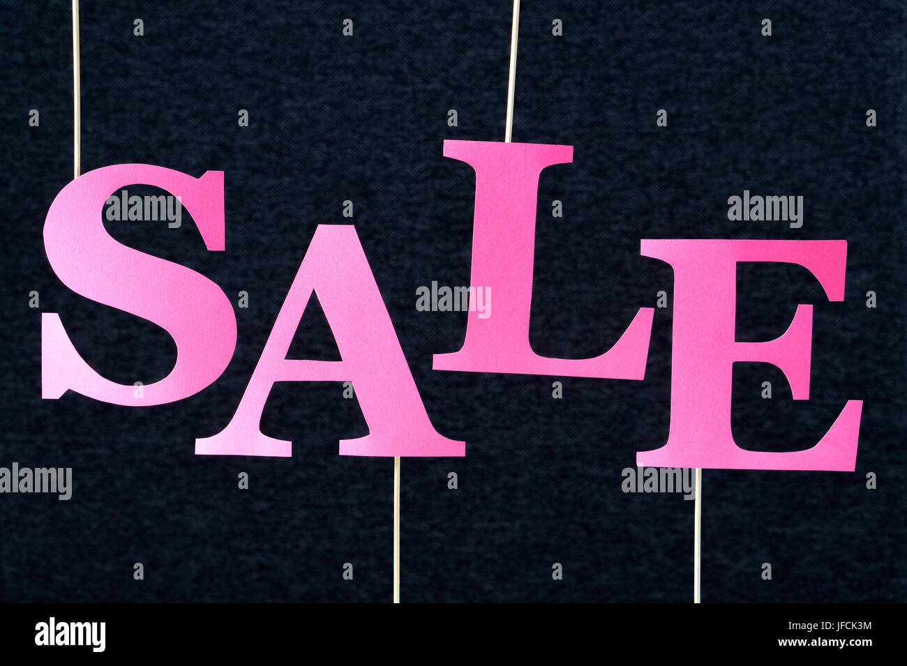 Fuchsia sale text on dark background. Pink red letters cut from ...